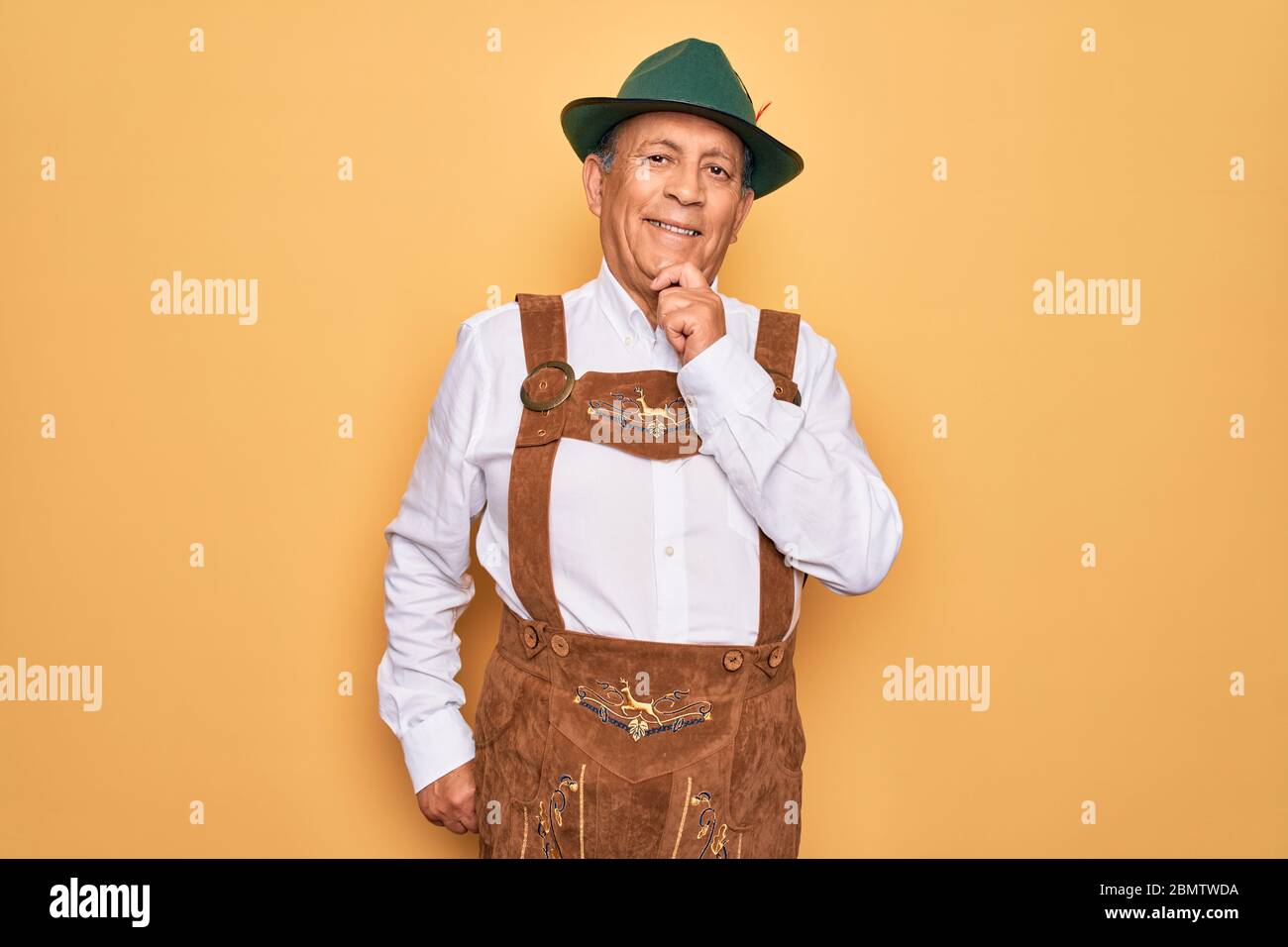 Senior grey-haired man wearing german traditional octoberfest suit over ...
