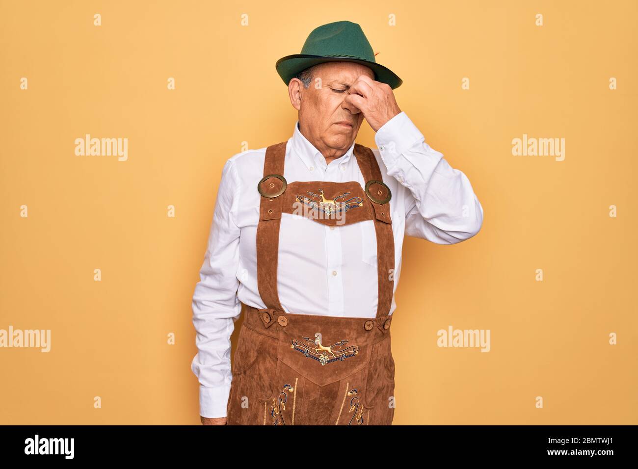 Senior grey-haired man wearing german traditional octoberfest suit over ...