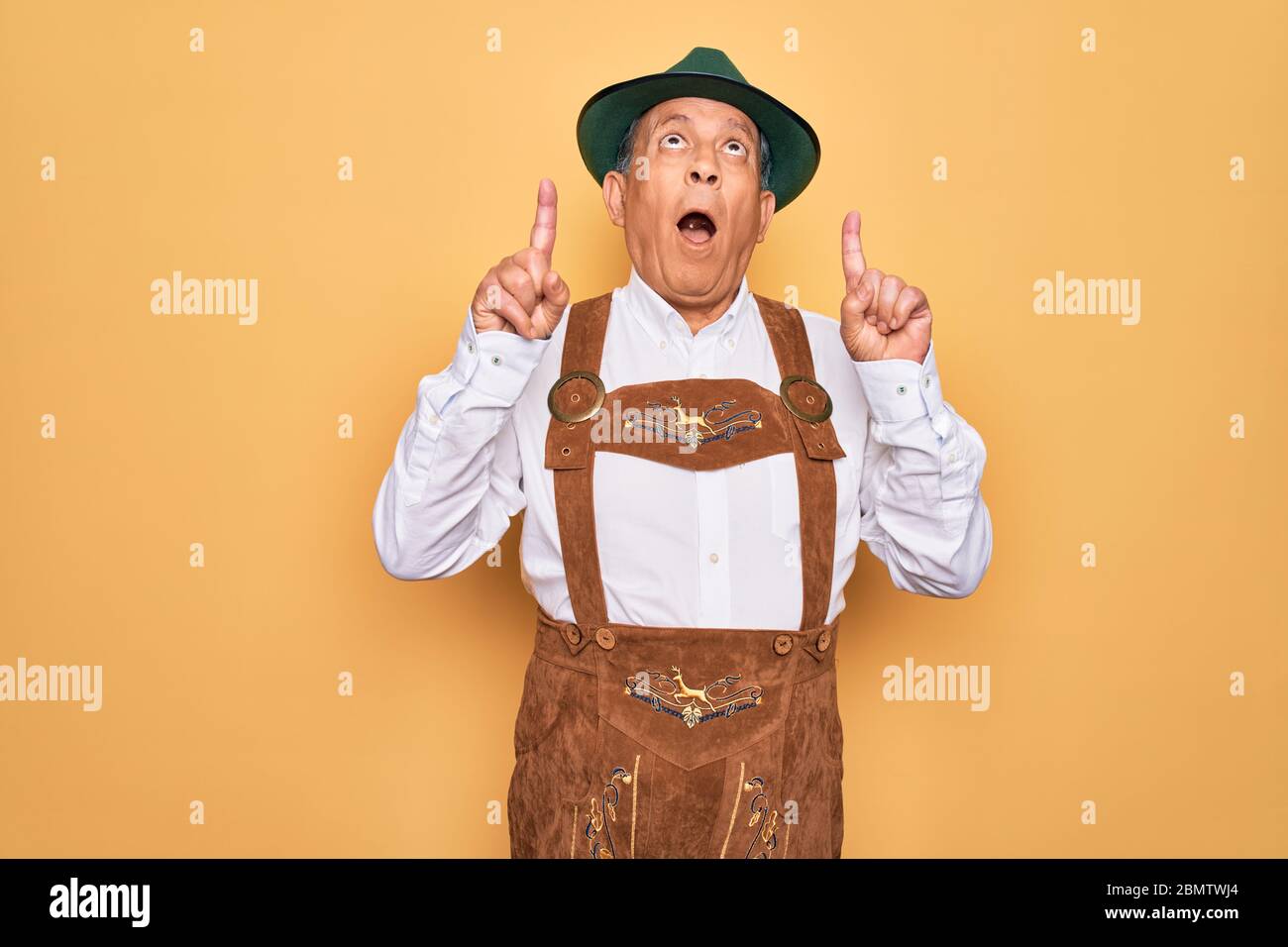 Senior grey-haired man wearing german traditional octoberfest suit over ...