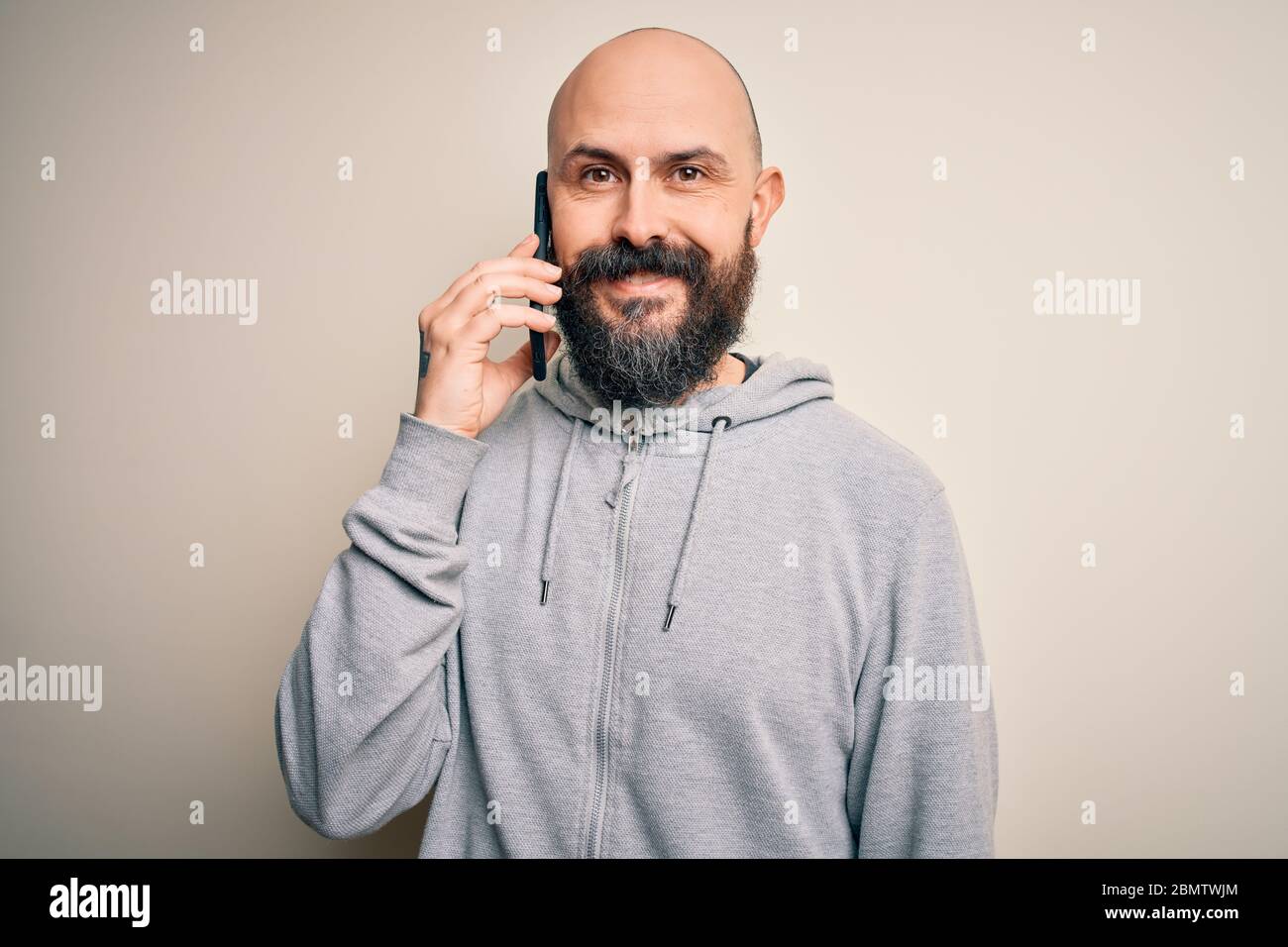 Handsome bald man with beard having conversation talking on the ...
