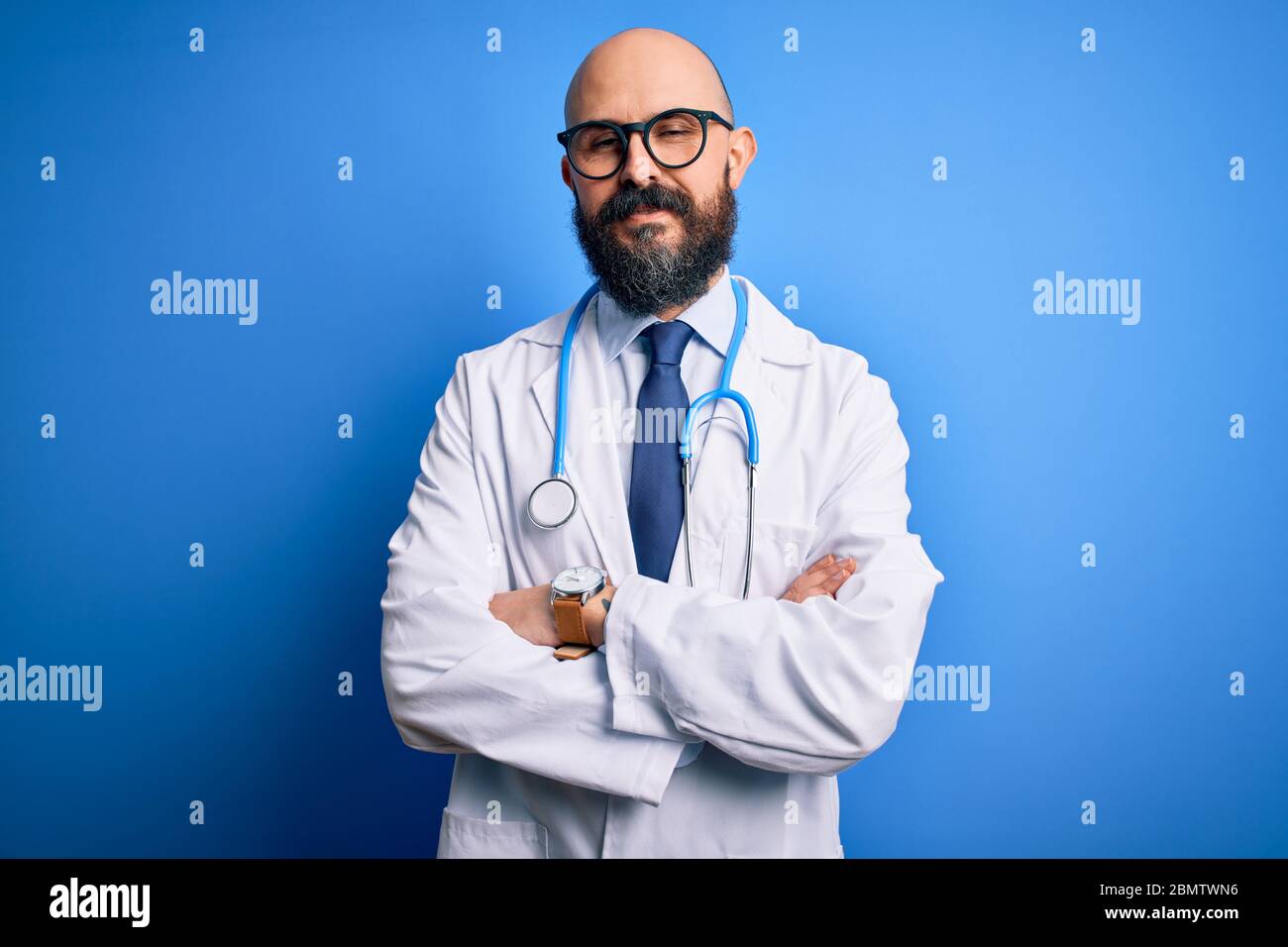 Handsome bald doctor man with beard wearing glasses and stethoscope ...