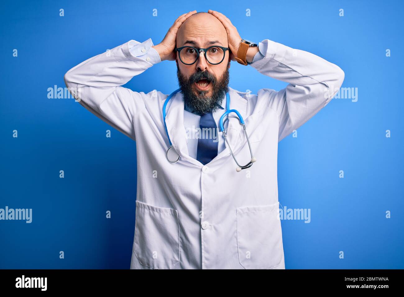 Handsome bald doctor man with beard wearing glasses and stethoscope ...