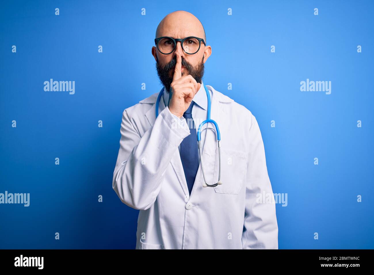 Handsome bald doctor man with beard wearing glasses and stethoscope ...