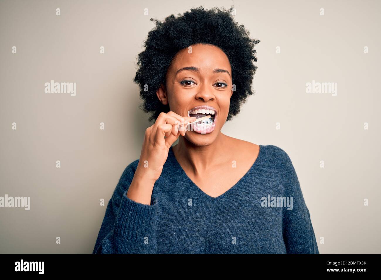 African american woman brushing her teeth using tooth brush and oral ...
