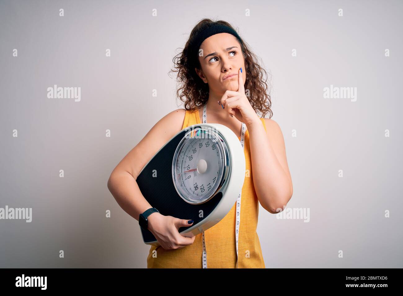 Thoughtful woman tape measure weight hi-res stock photography and ...