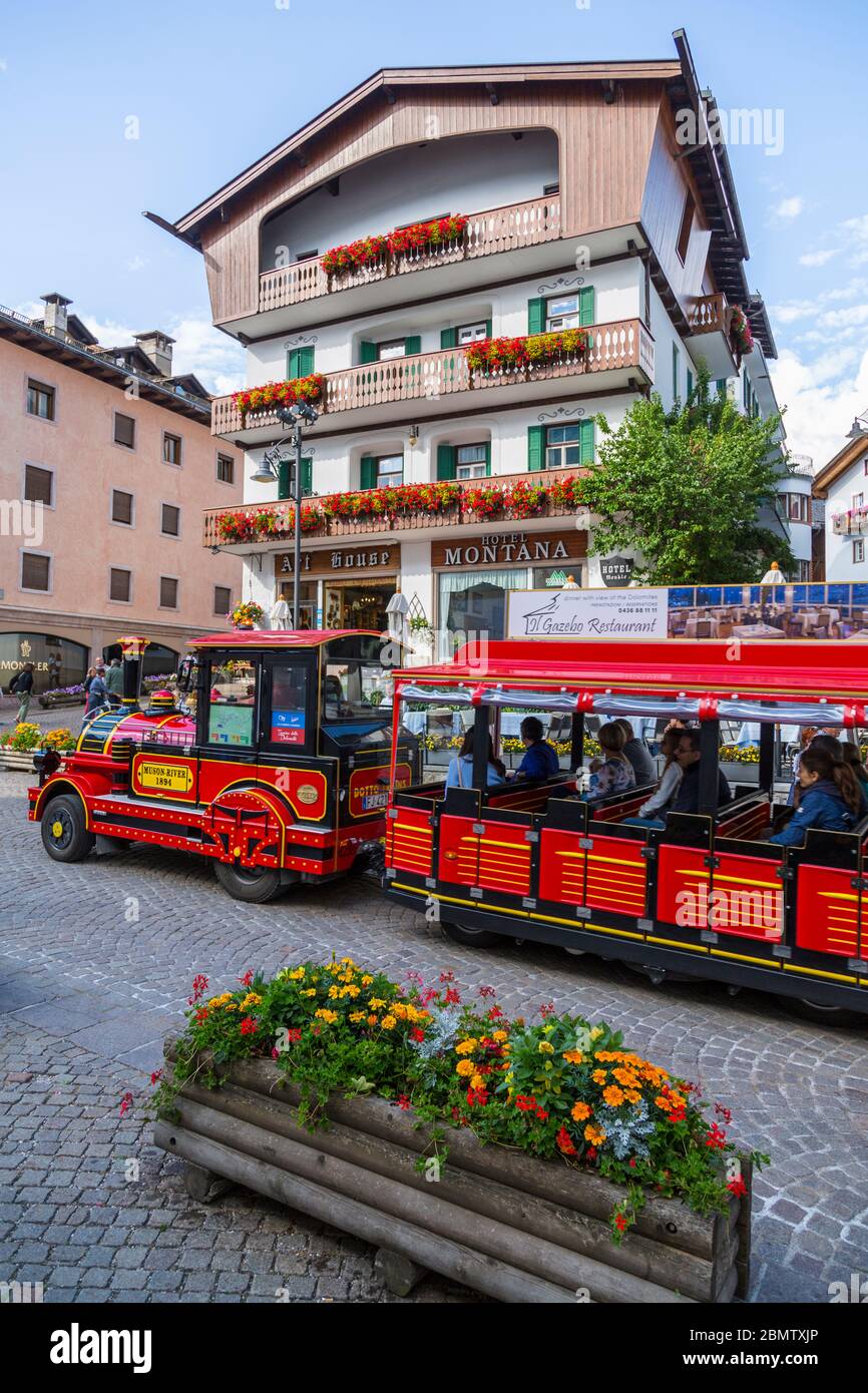 View of little city tour train in shopping area, Cortina d'Ampezzo ...