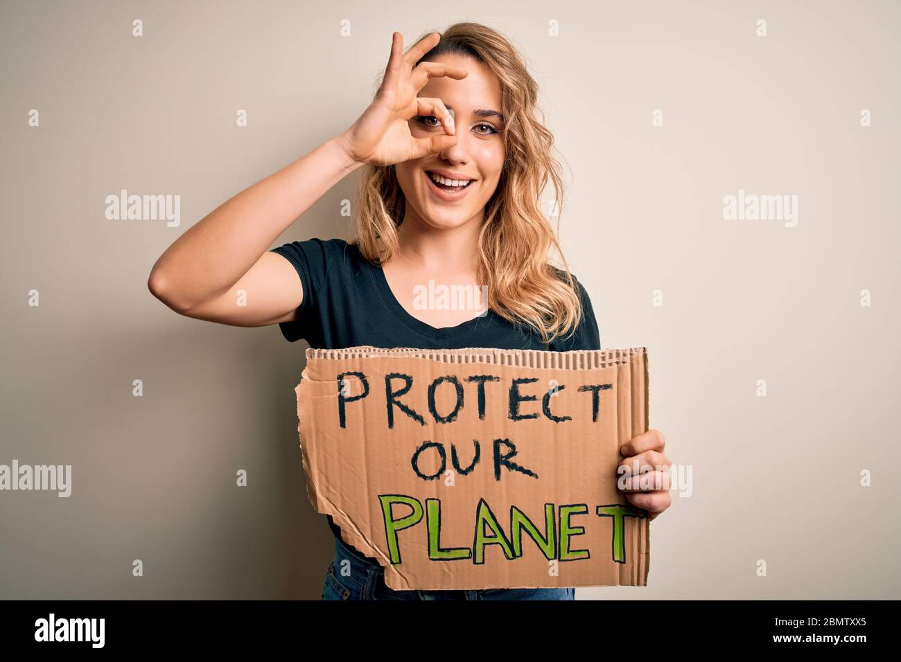Young activist woman asking for environment holding banner with protect ...