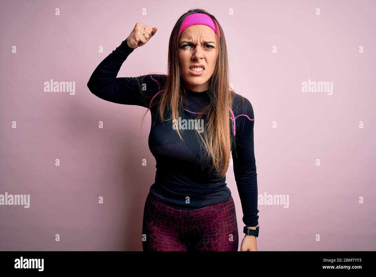 Young blonde fitness woman wearing sport workout clothes over isolated ...