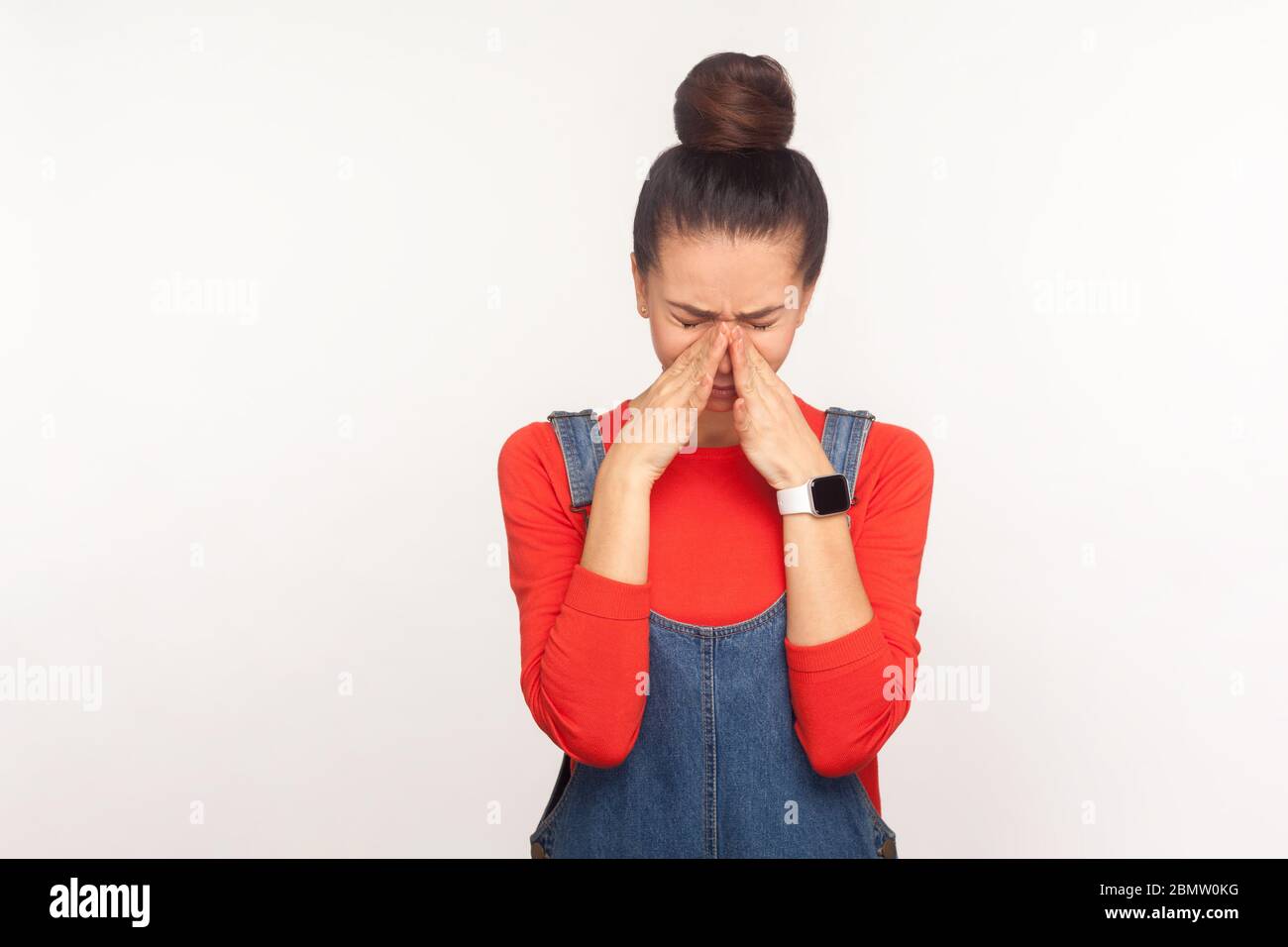 Sadness and depression. Portrait of upset girl with hair bun in denim ...