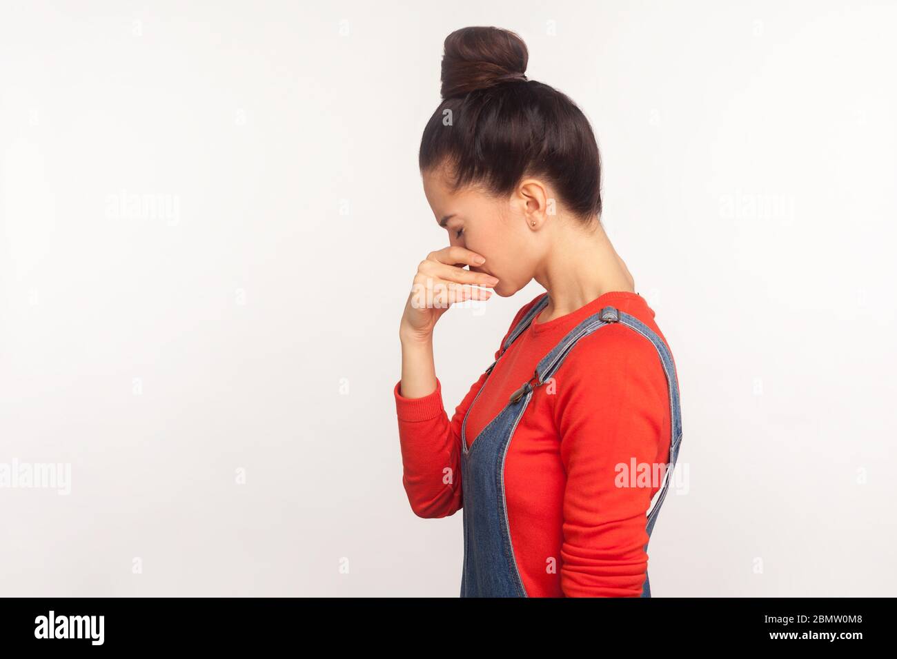 Sadness and depression. Side view of unhappy girl with hair bun in ...