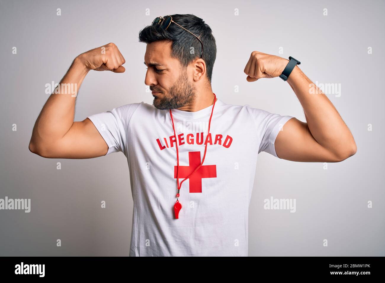 Young handsome lifeguard man with beard wearing t-shirt with red cross ...