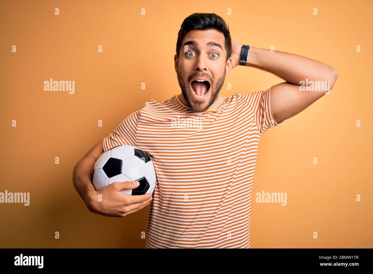 Handsome player man with beard playing soccer holding footballl ball ...