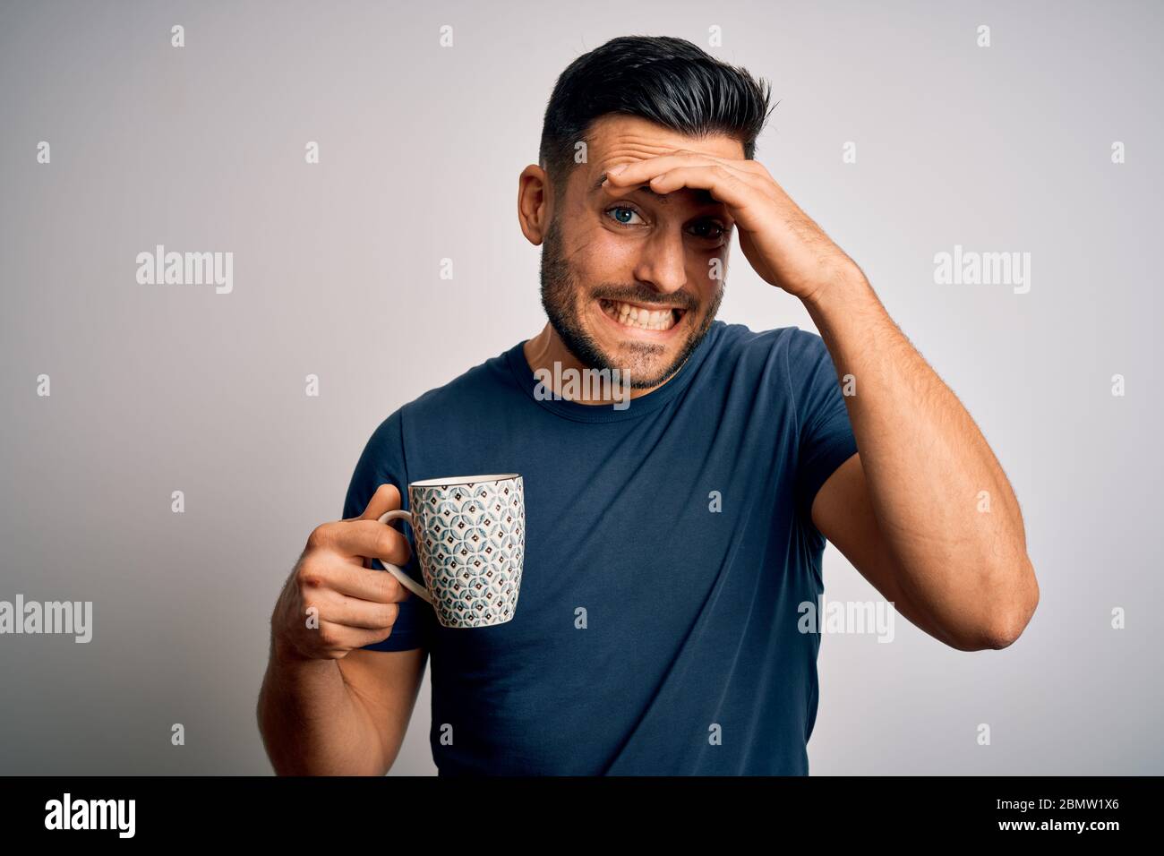 Young handsome man drinking a cup of hot coffee over white isolated ...