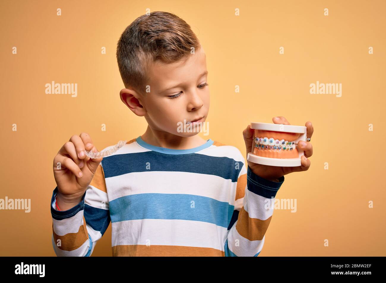 Little kid boy holding professional orthodontic denture with metal ...