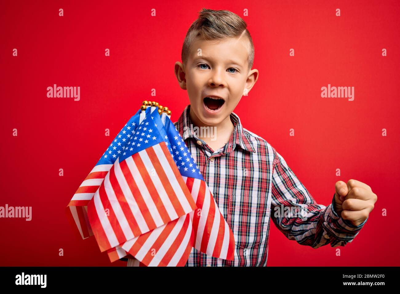 Young little american patriotic caucasian kid holding flag of USA over ...