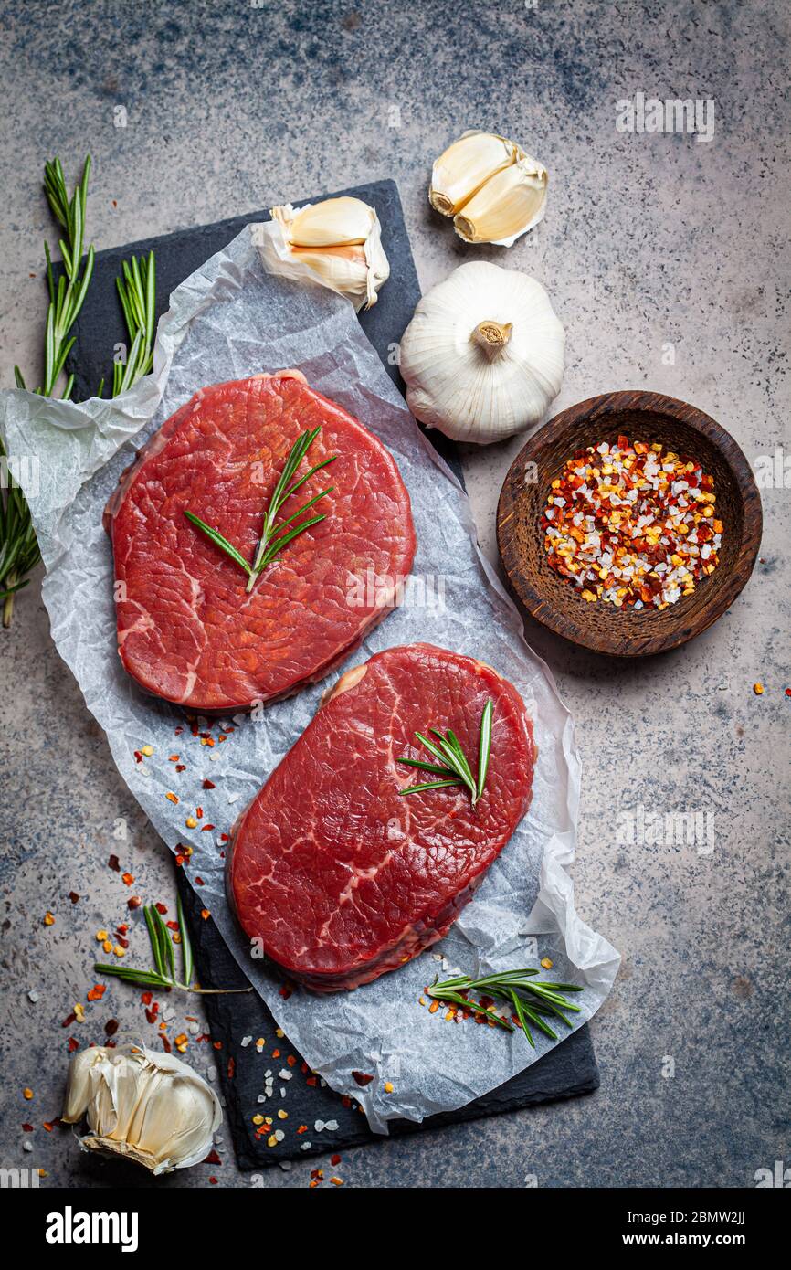 Raw beef fillet on a slate with spices. Raw meat beef steaks background ...