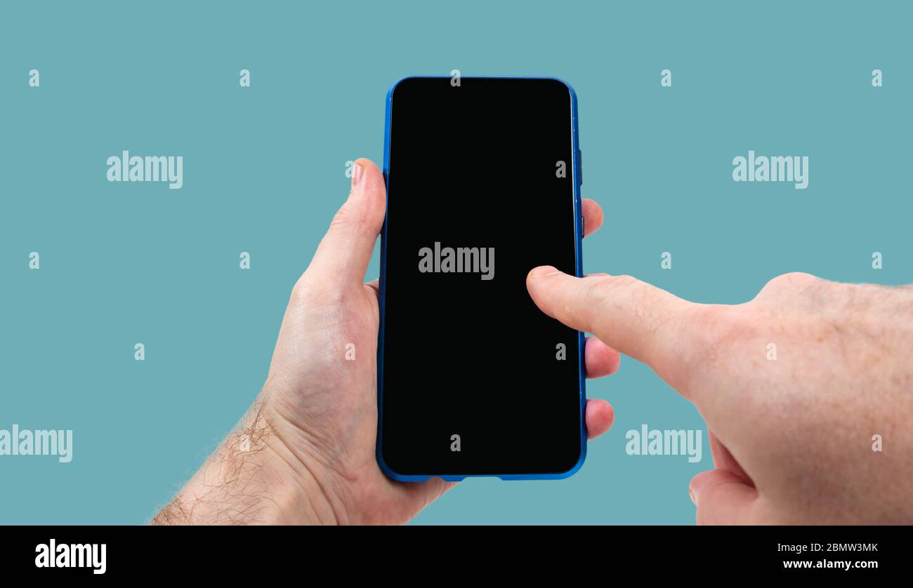 smartphone used by human hand on blue background Stock Photo - Alamy