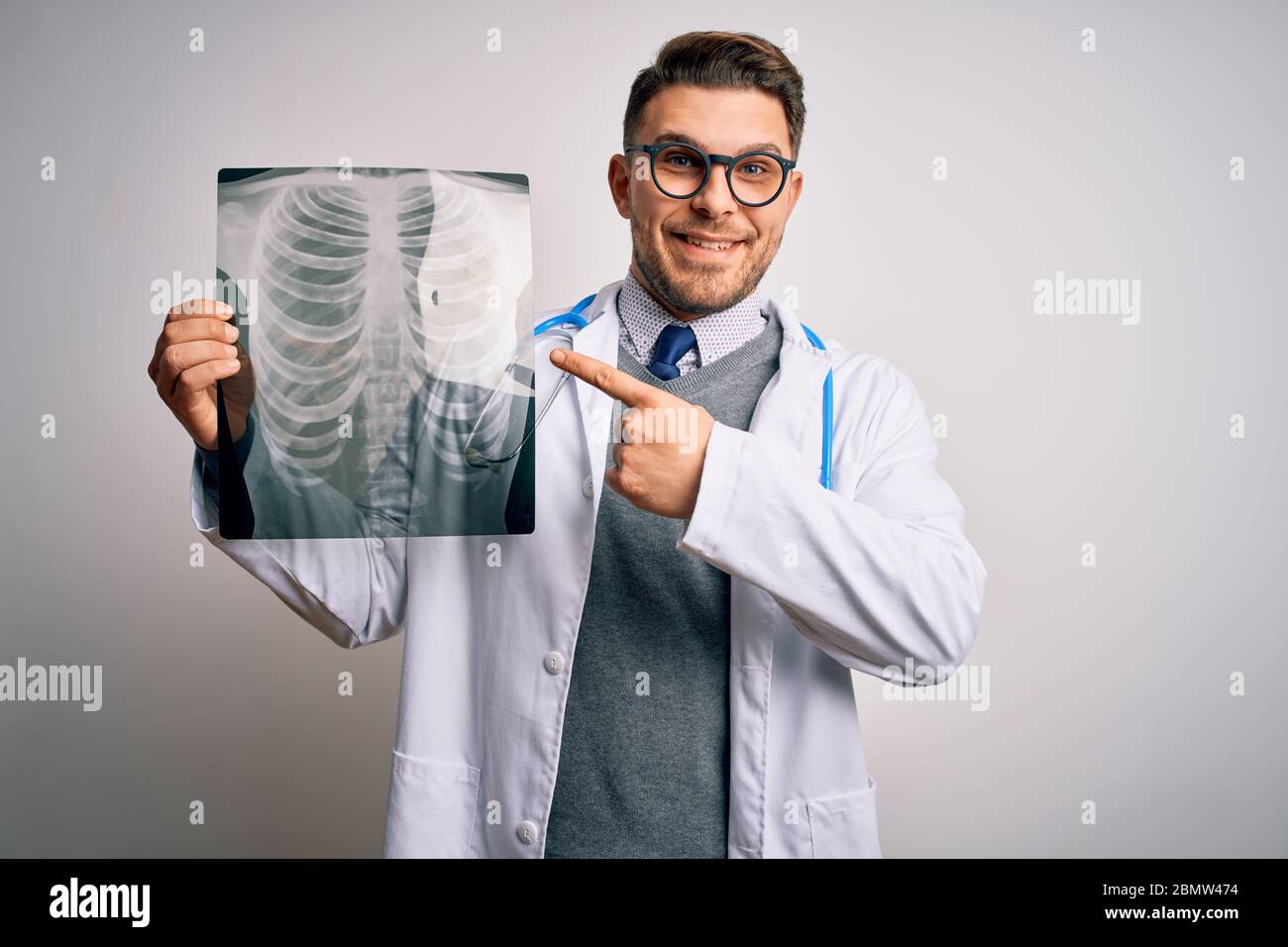 Young doctor man wearing medical coat looking at chest scan radiography ...
