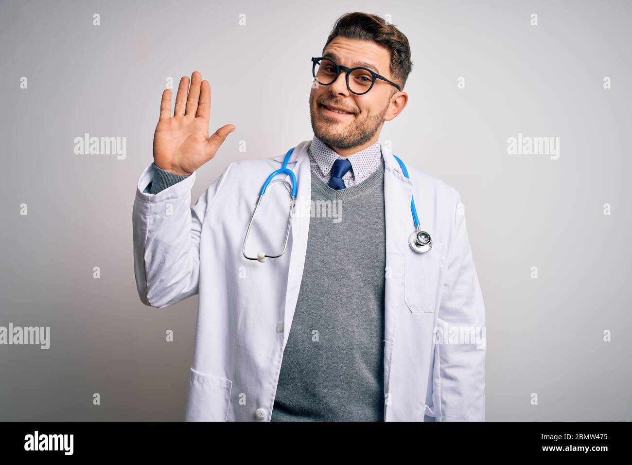 Young doctor man with blue eyes wearing medical coat and stethoscope ...