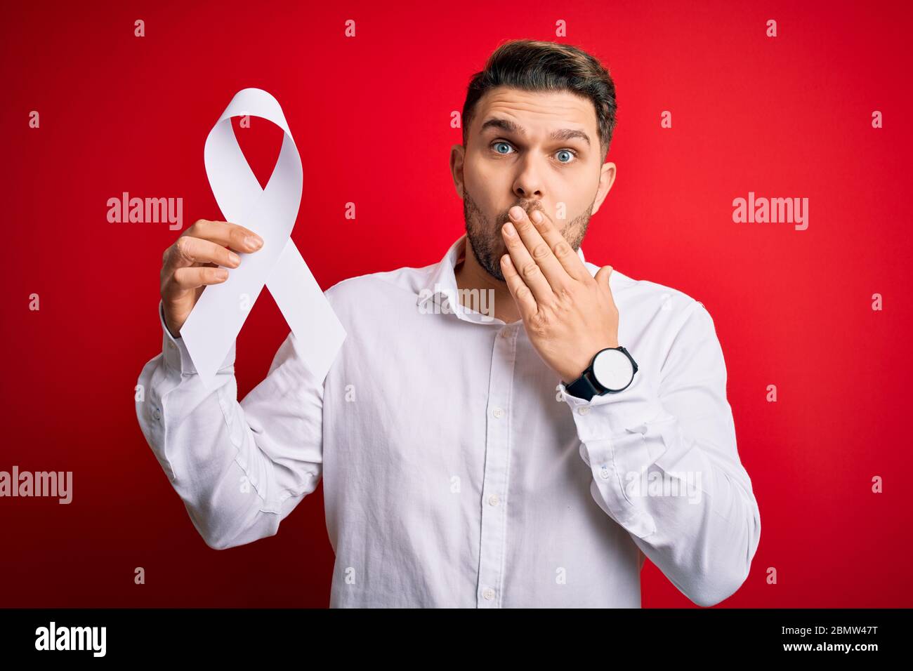 Young man with blue eyes holding white ribbon as lung cancer awareness ...