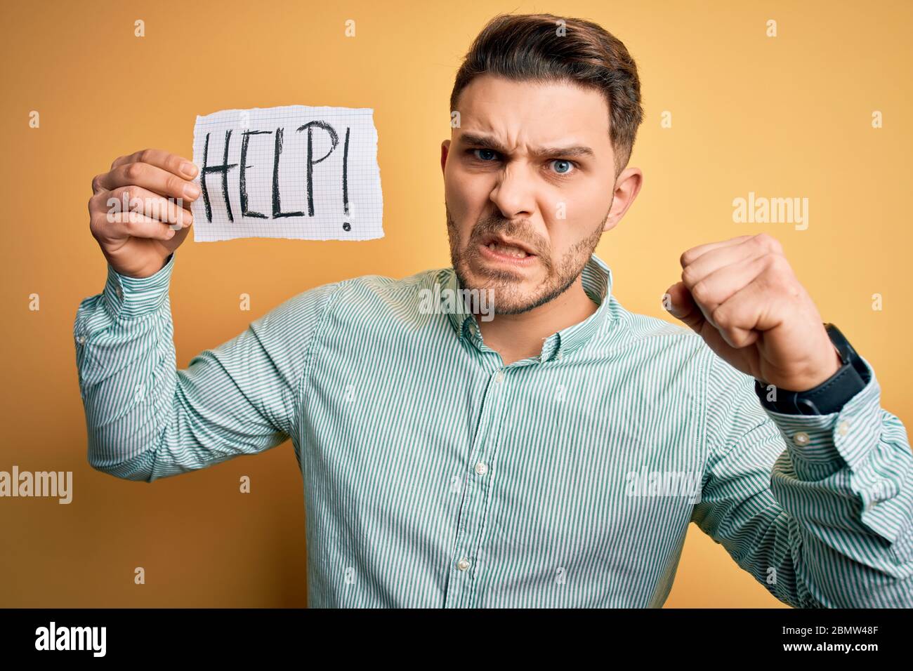 Young business man with blue eyes asking for help holding paper note ...