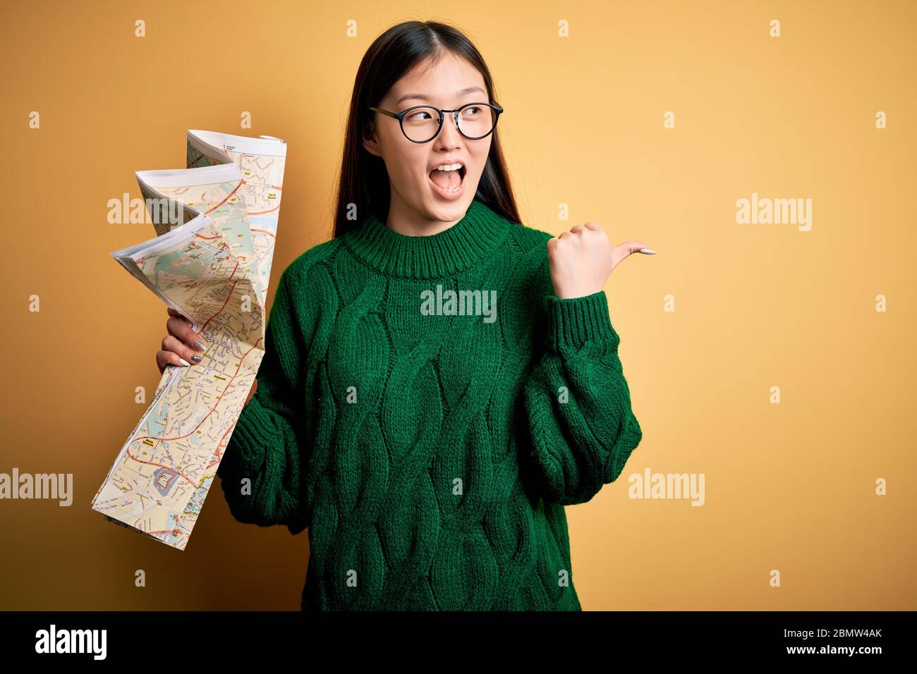 Young asian turist woman looking at city tourist map on a trip over ...