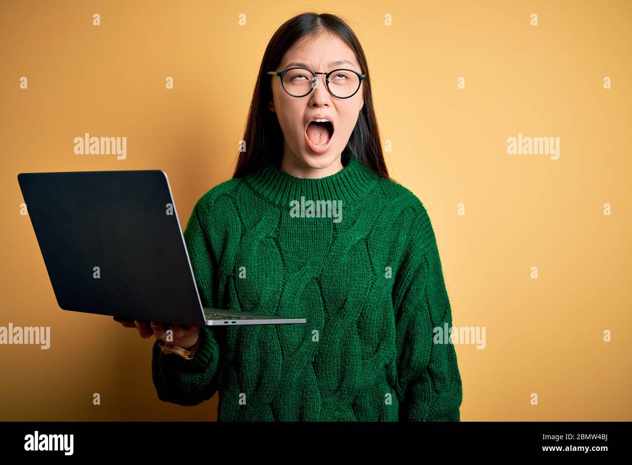 Young asian business woman wearing glasses and working using computer ...
