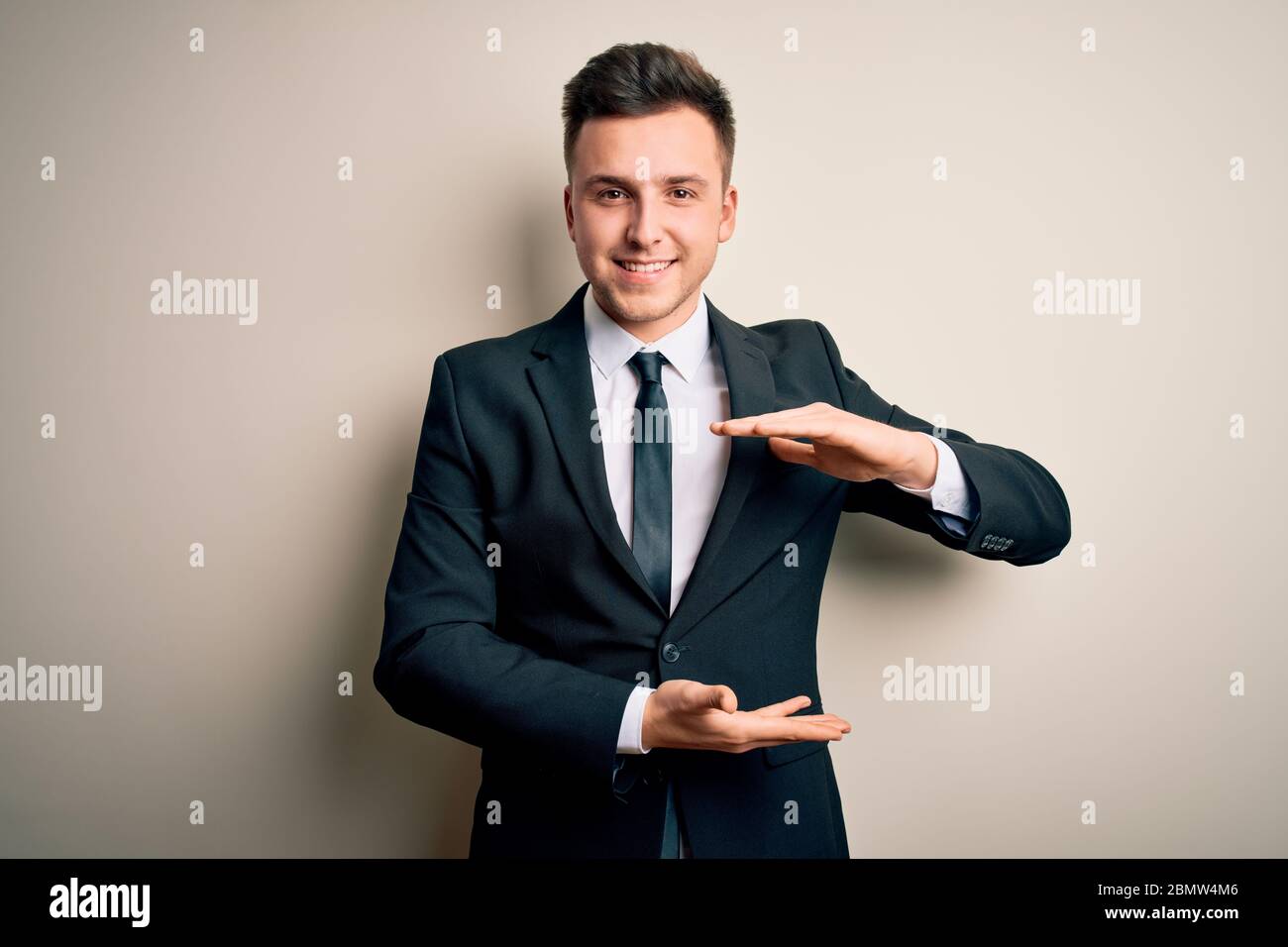 Young handsome business man wearing elegant suit and tie over isolated ...