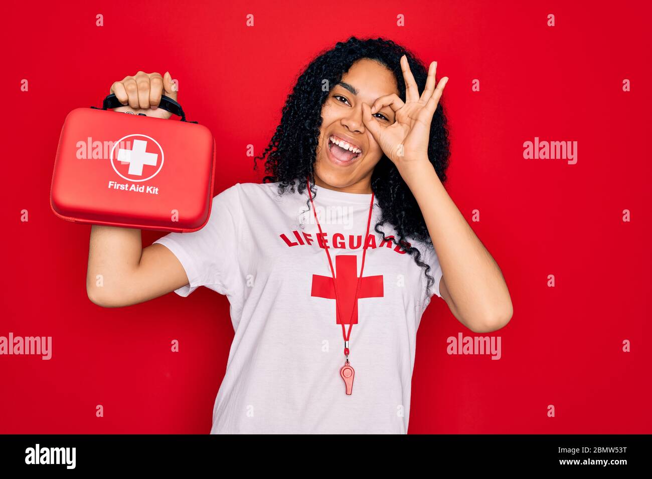 Young african american curly lifeguard woman wearing whistle holding ...