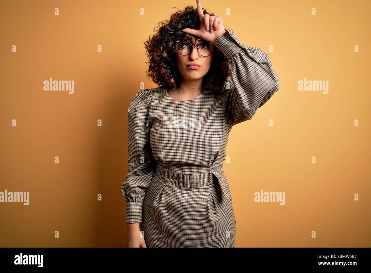Beautiful arab business woman wearing dress and glasses standing over ...