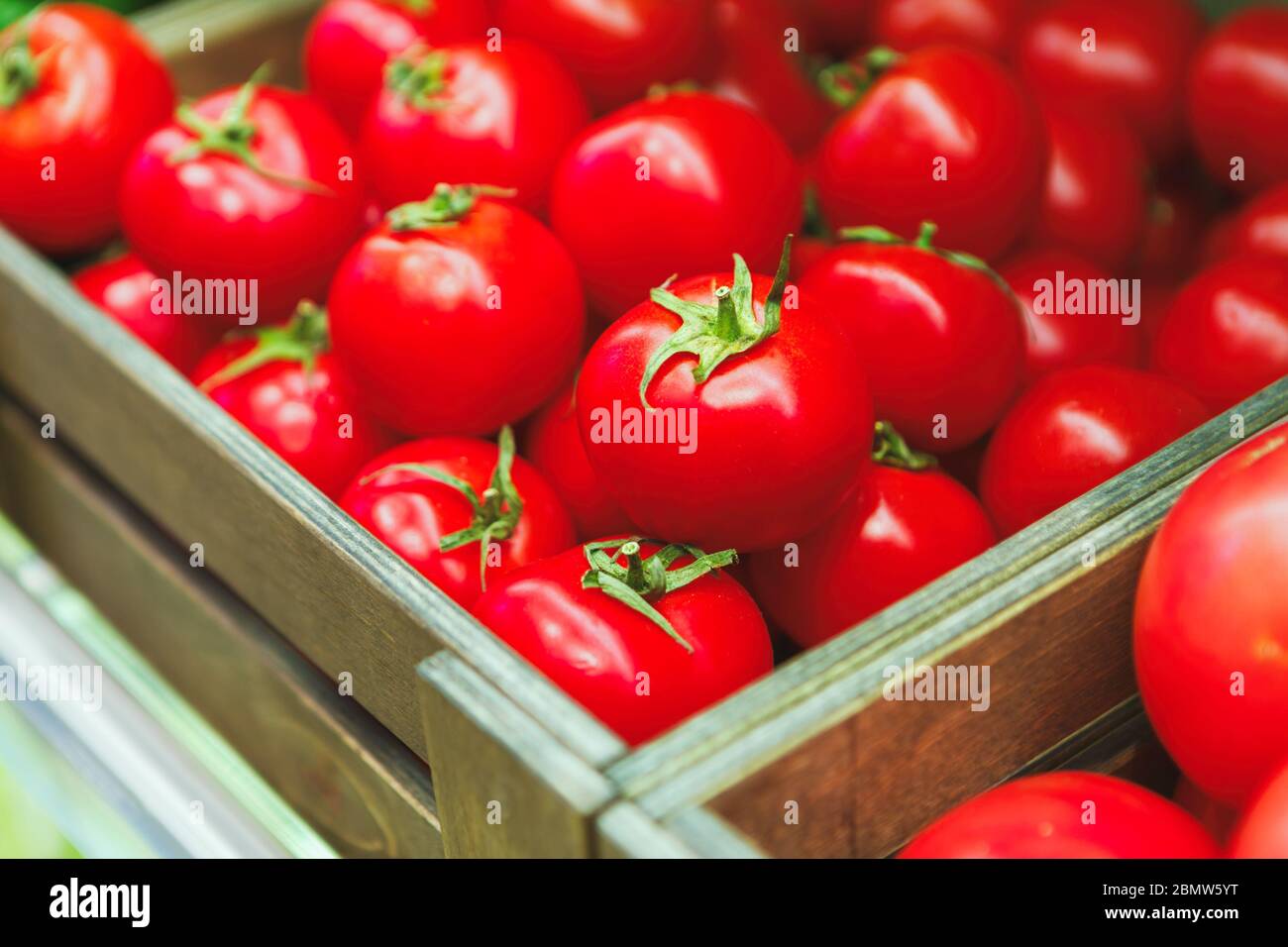 Buy ripe red tomatoes in grocery store.Delicious fresh tomato in wooden ...