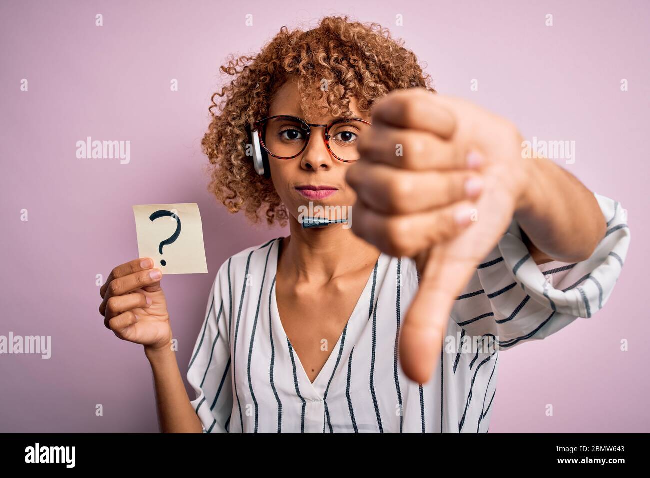 African american call center agent woman using headset holding paper ...