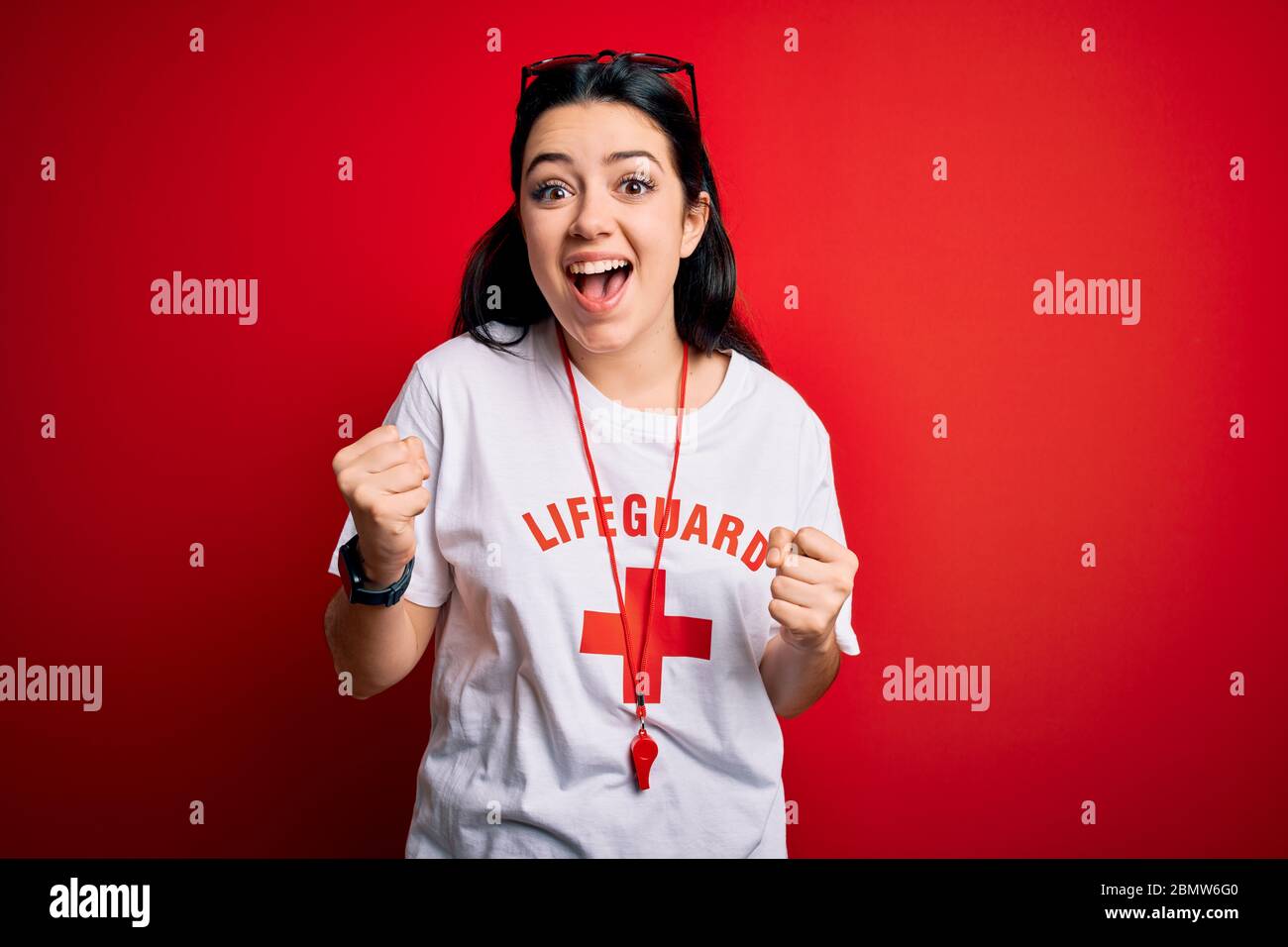 Young lifeguard woman wearing secury guard equipent over red background ...