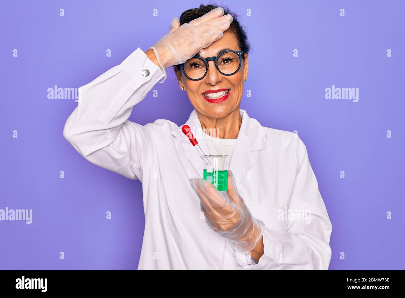 Middle age senior scientist woman wearing laboratory coat holding ...