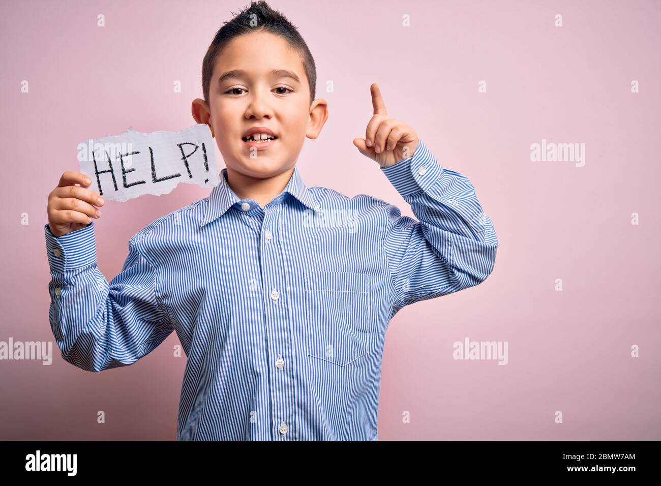 Young little boy kid holding paper sing with help message asking for ...
