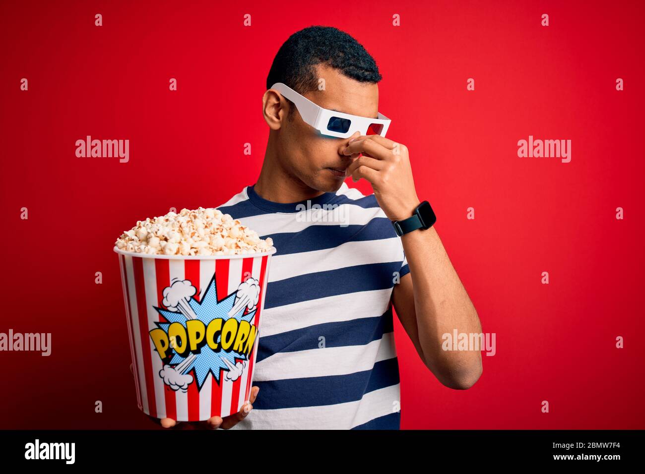 Young handsome african american man watching movie using 3d glasses ...