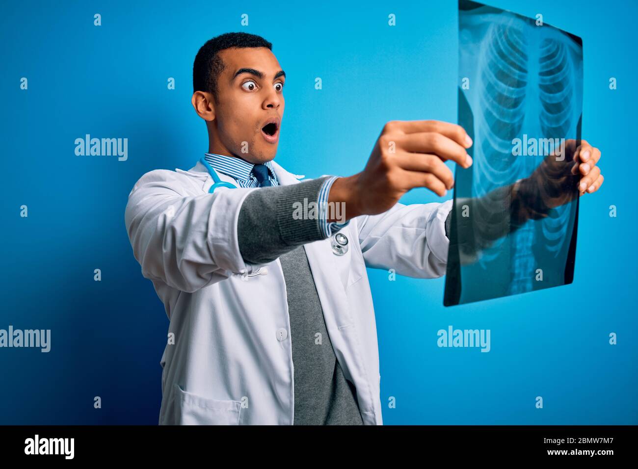 Handsome african american doctor man wearing stethoscope holding chest ...