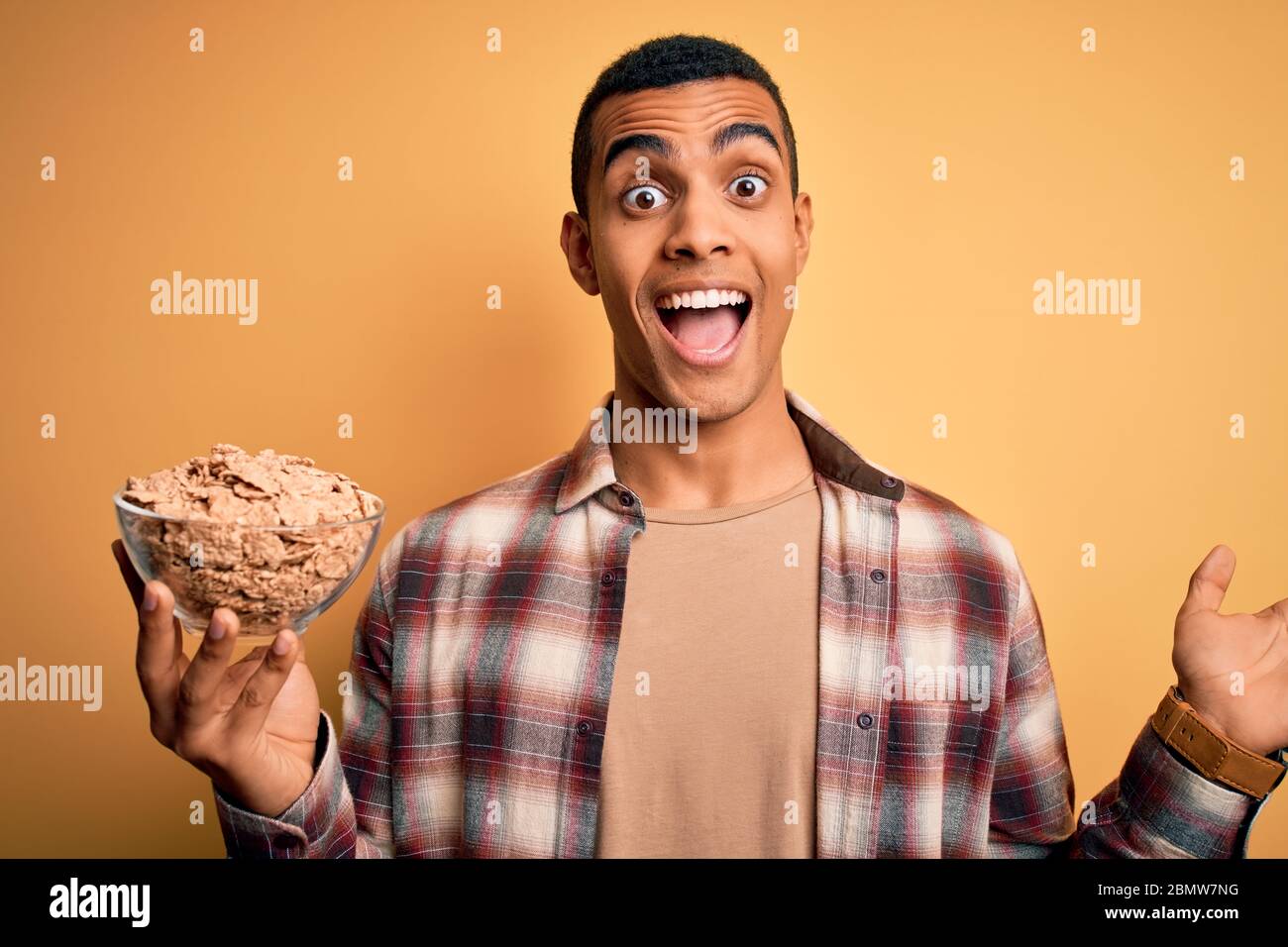 Young handsome african american man holding bowl with healthy ...