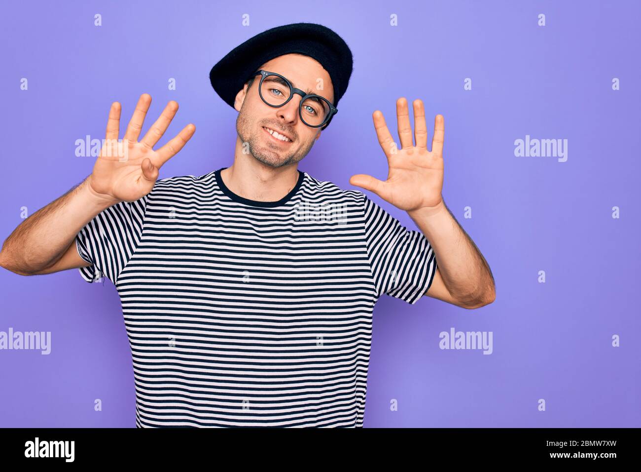 Handsome man with blue eyes wearing striped t-shirt and french beret ...