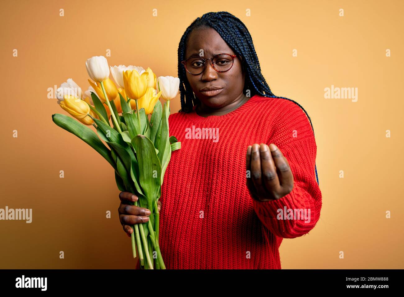Young african american plus size woman with braids holding bouquet of ...