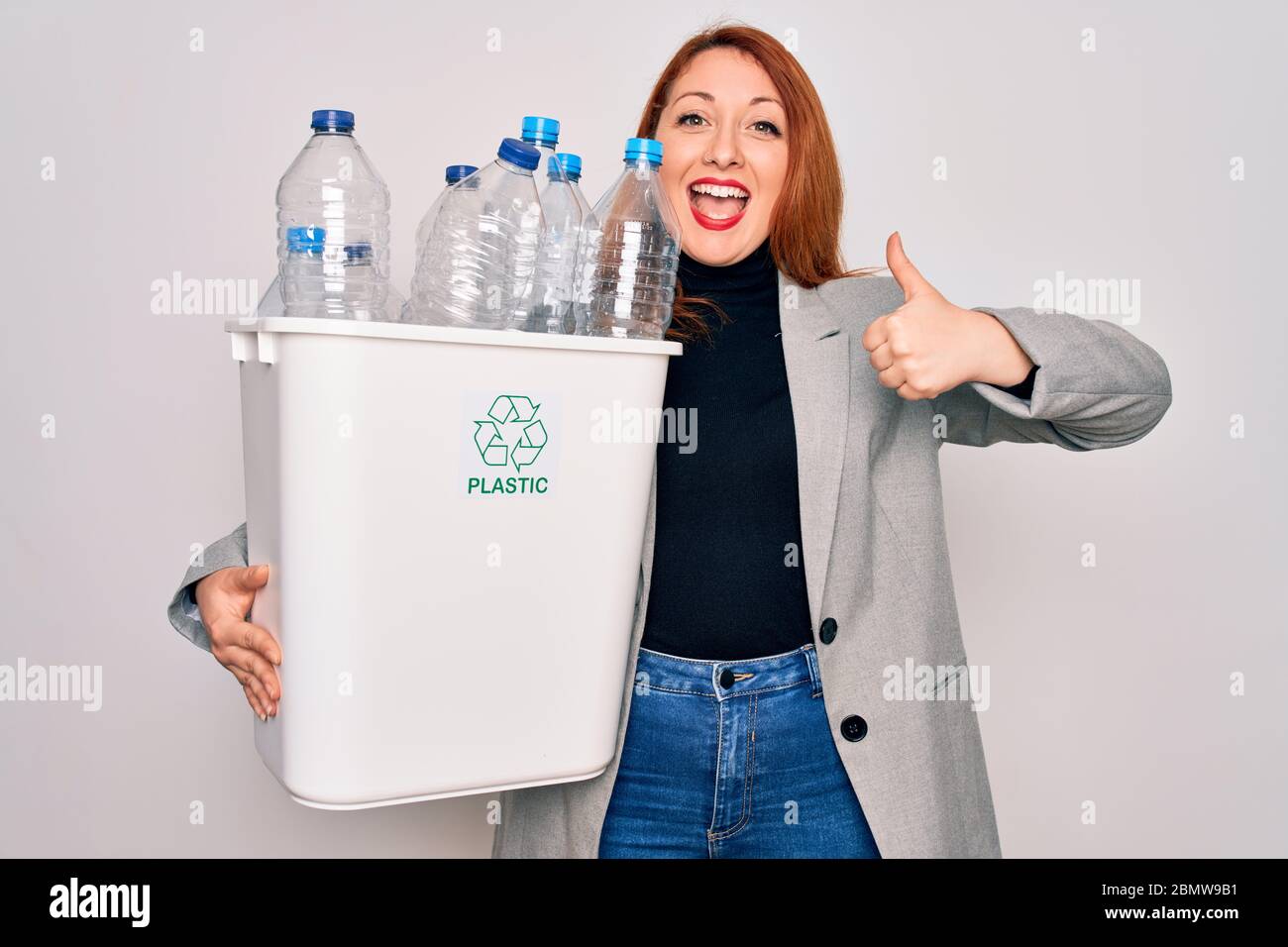 Young beautiful redhead woman recycling holding trash can with plastic ...