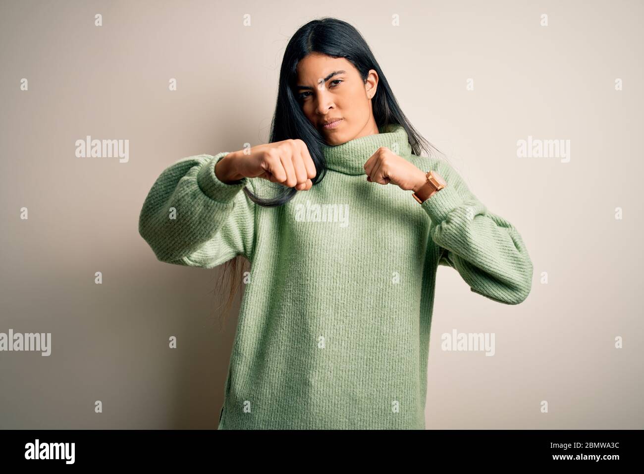 Young beautiful hispanic woman wearing green winter sweater over ...