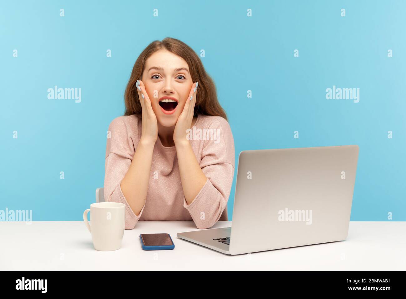 Wow, unbelievable! Surprised astonished young woman employee sitting at ...