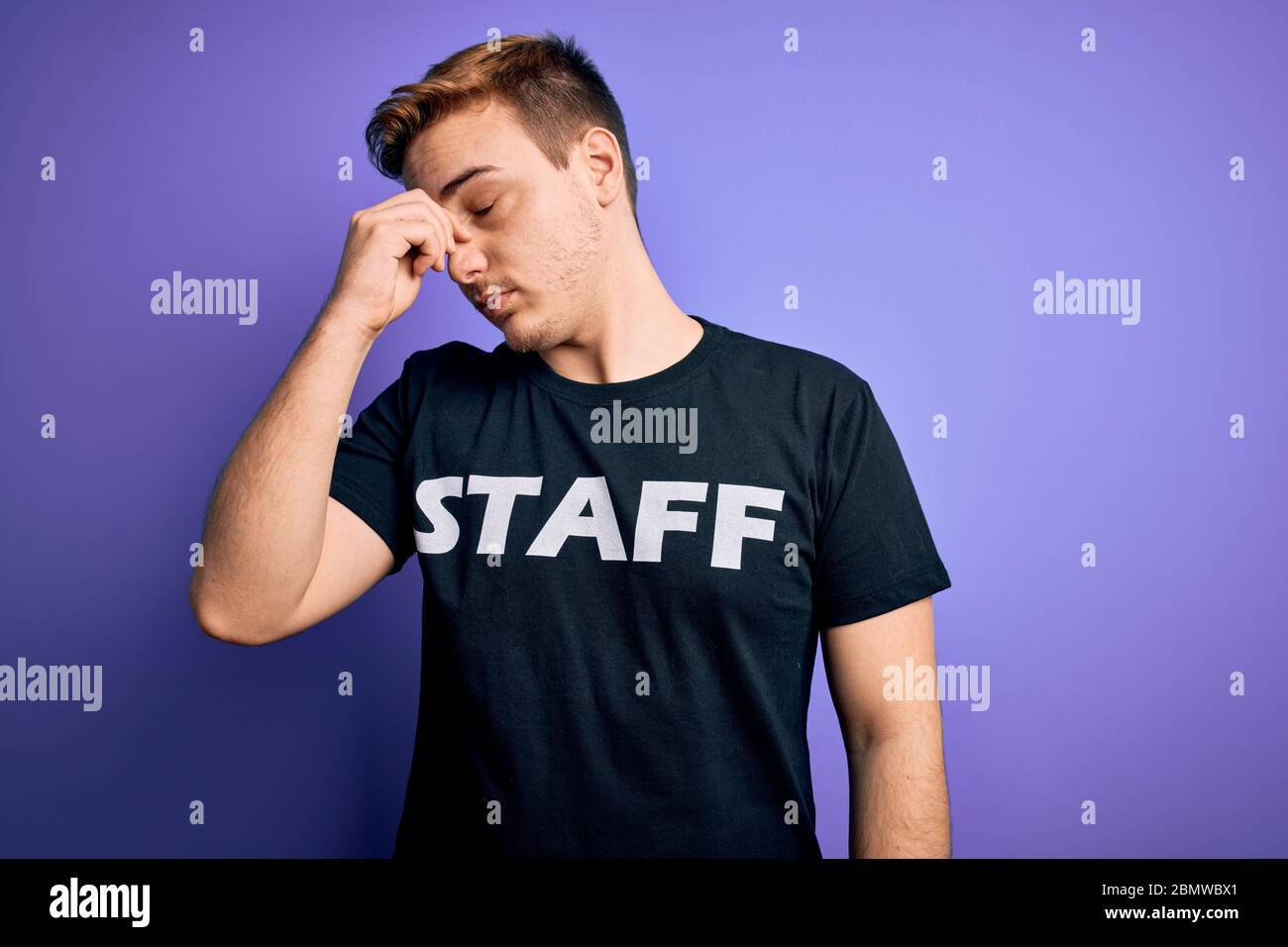 Young handsome redhead worker man wearing staff t-shirt uniform over ...