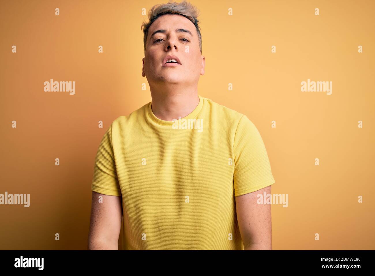 Young handsome modern man wearing yellow shirt over yellow isolated ...