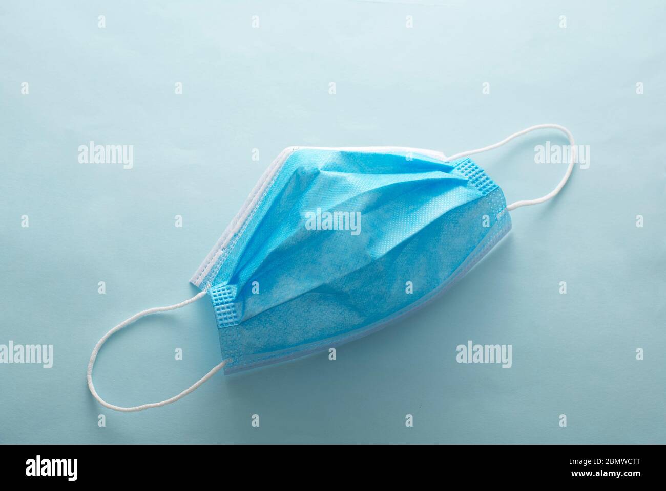 Surgical face mask over a white background with copy space in a concept ...