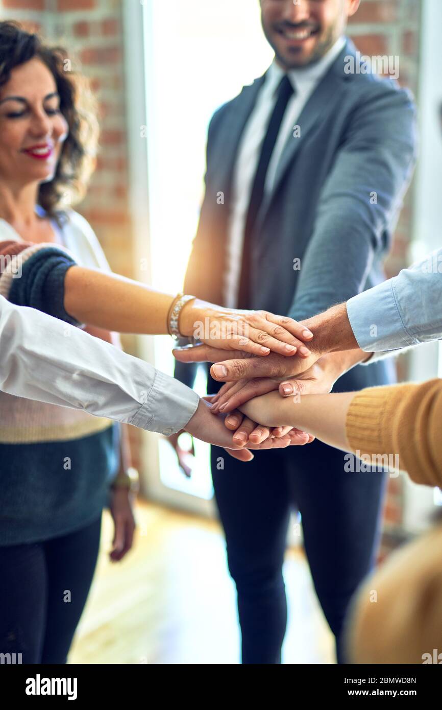 Group of business workers standing with hands together at the office ...
