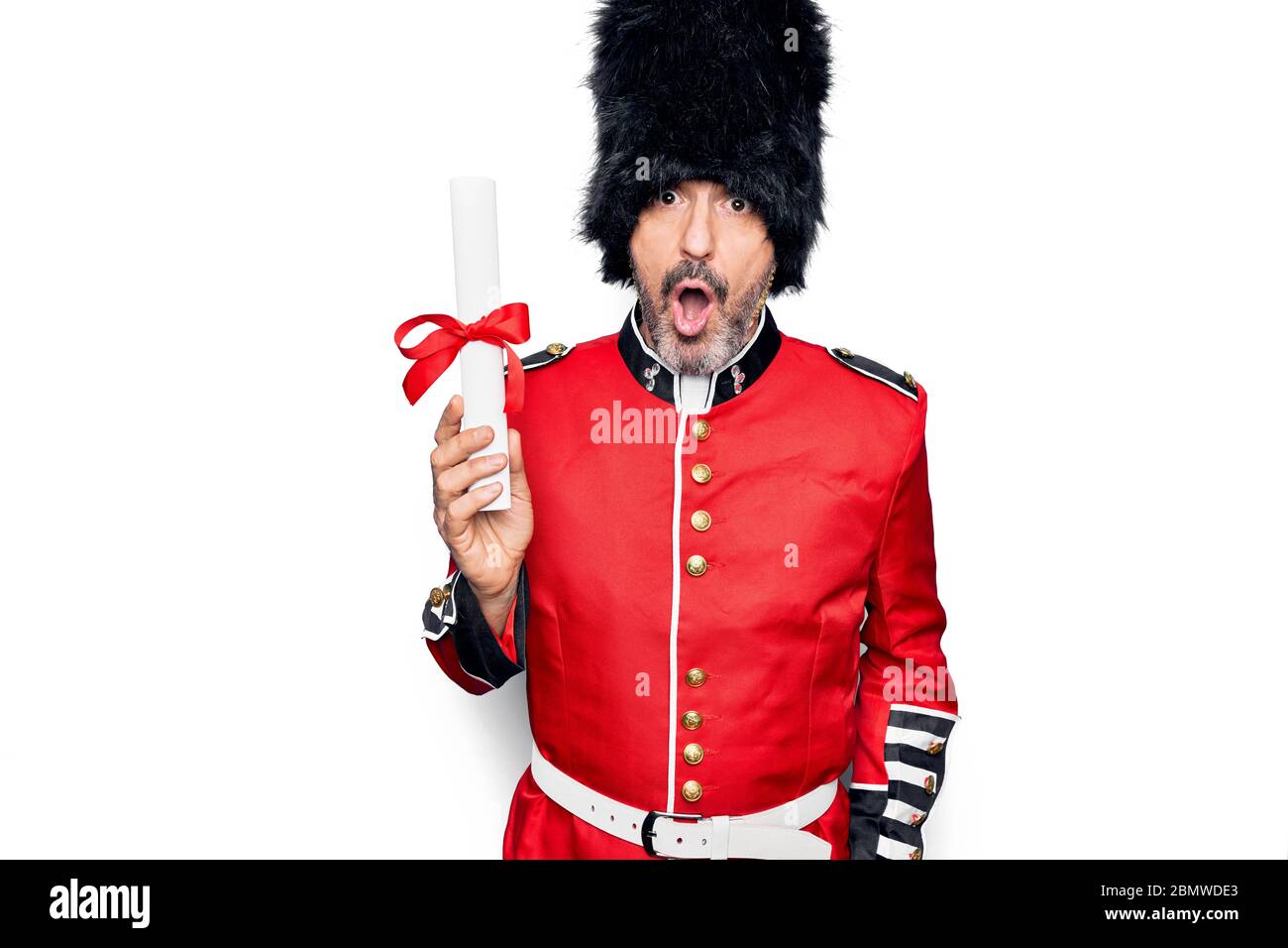 Middle age handsome wales guard man wearing traditional uniform holding ...