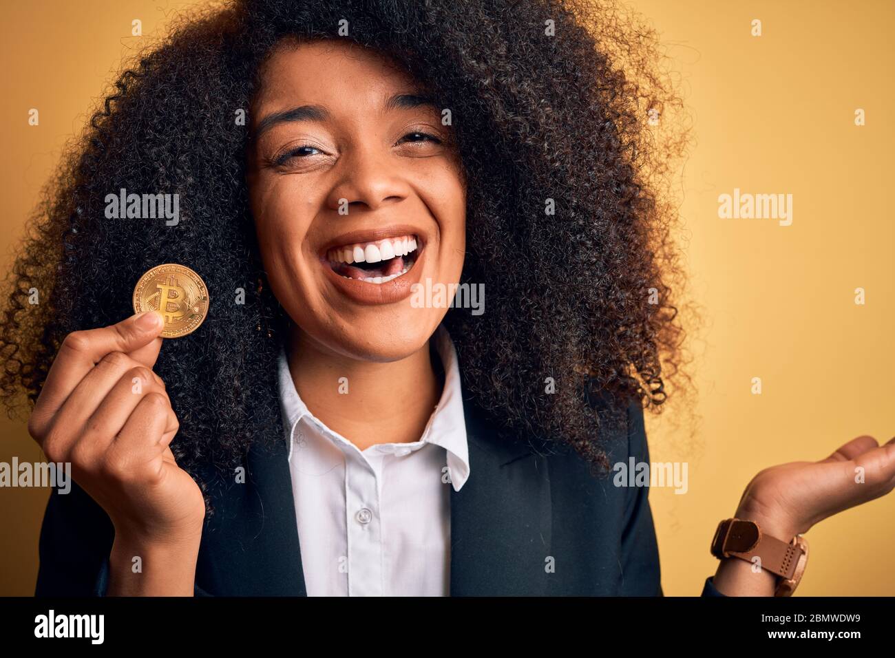 Young african american business woman with afro hair holding bitcoin ...