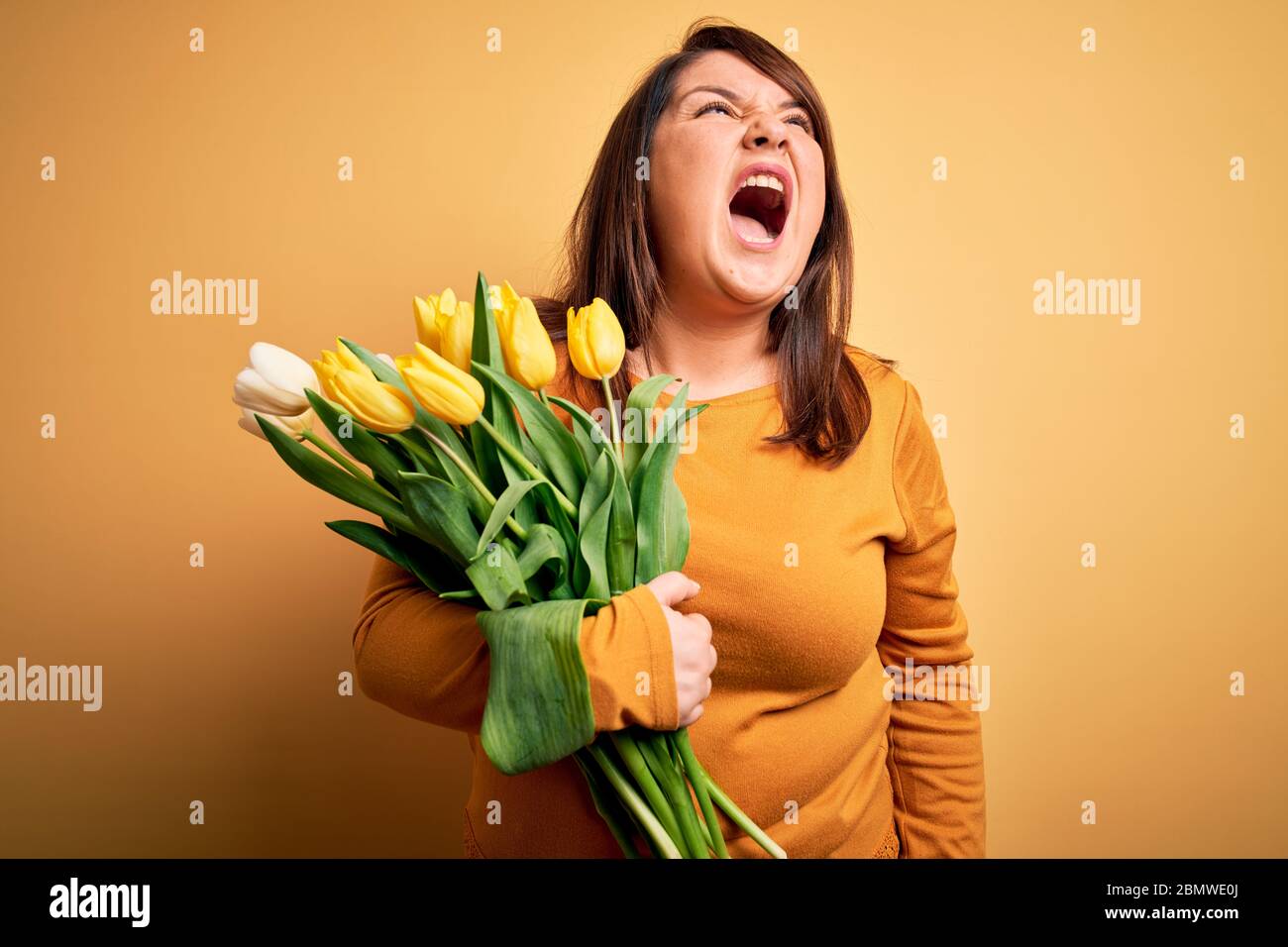 Beautiful plus size woman holding romantic bouquet of natural tulips ...